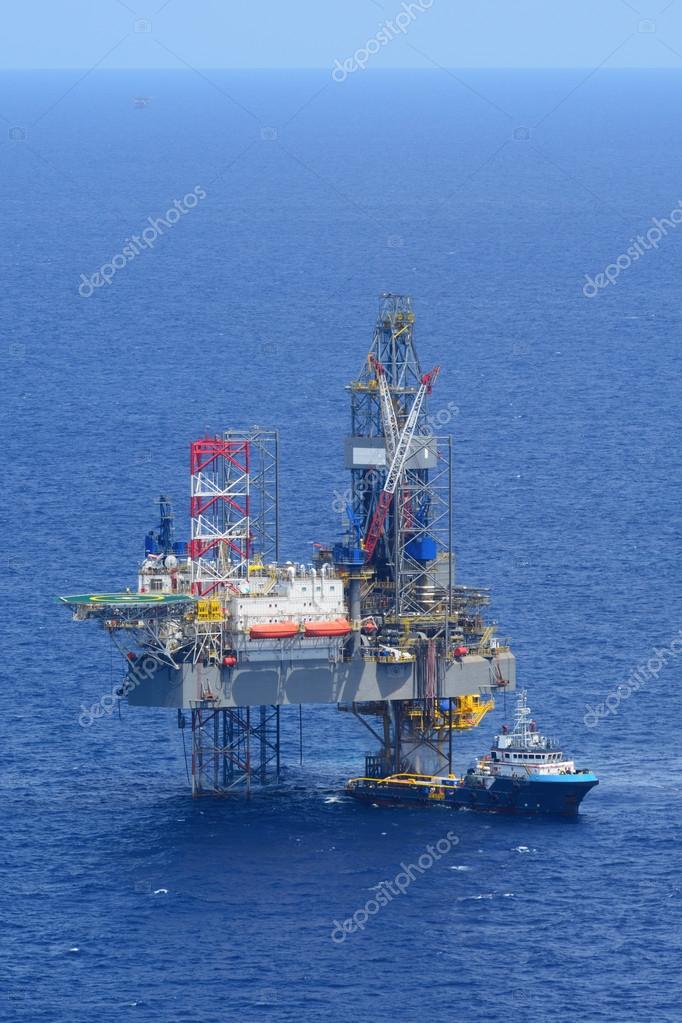 The offshore drilling oil rig and supply boat side view Stock Photo by ...