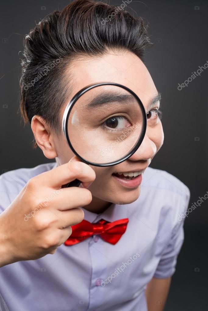 Vietnamese man looking through magnifier Stock Photo by ©DragonImages ...