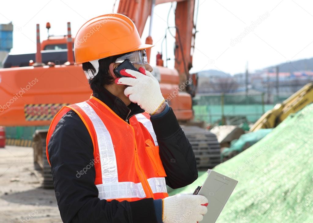 Trabajador de la construcci n con planos de construcci n y tel fono celular 2024
