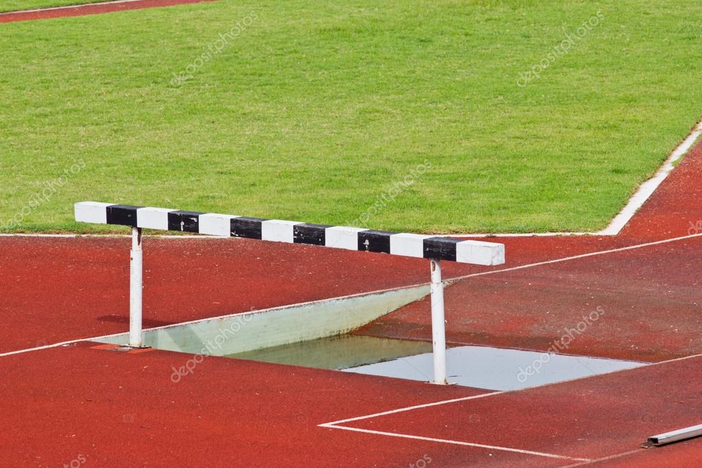 Obstáculos en la pista de atletismo roja preparada para la competición ...