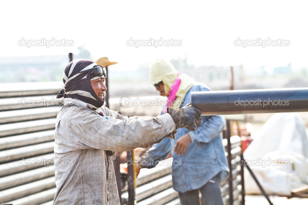 Construction worker carrying iron pipe — Stock Photo © thailandonly ...