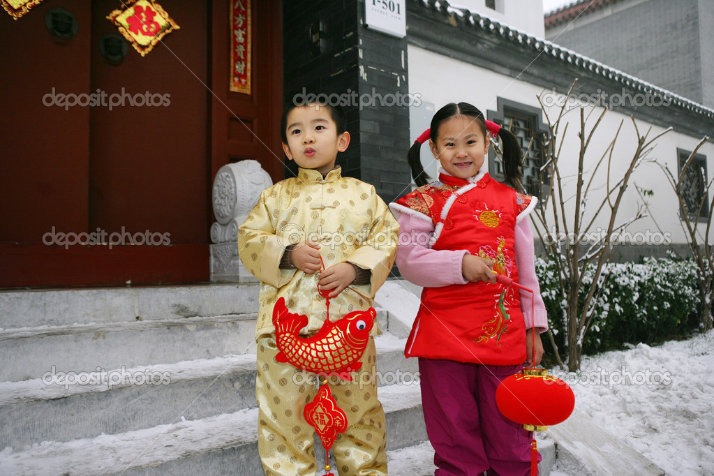 Two children(5-31 years) standing in front of chinese traditiona ...