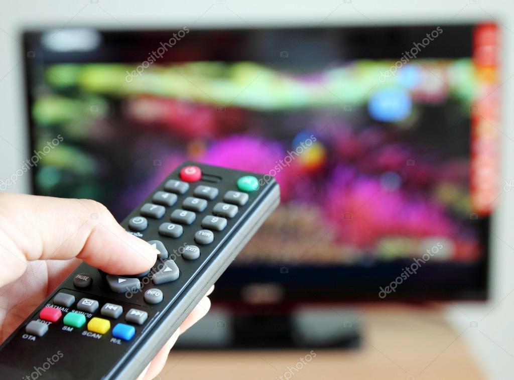 Mano apuntando un control remoto de televisión hacia la televisión 2023