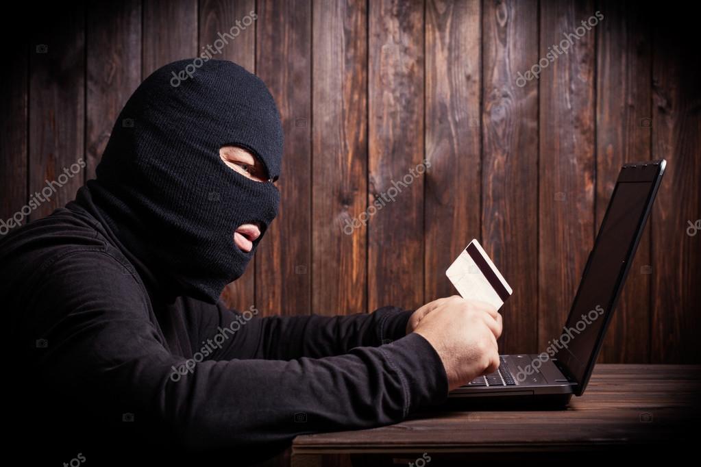 Hacker holding a credit card Stock Photo by ©merrydolla 48876771