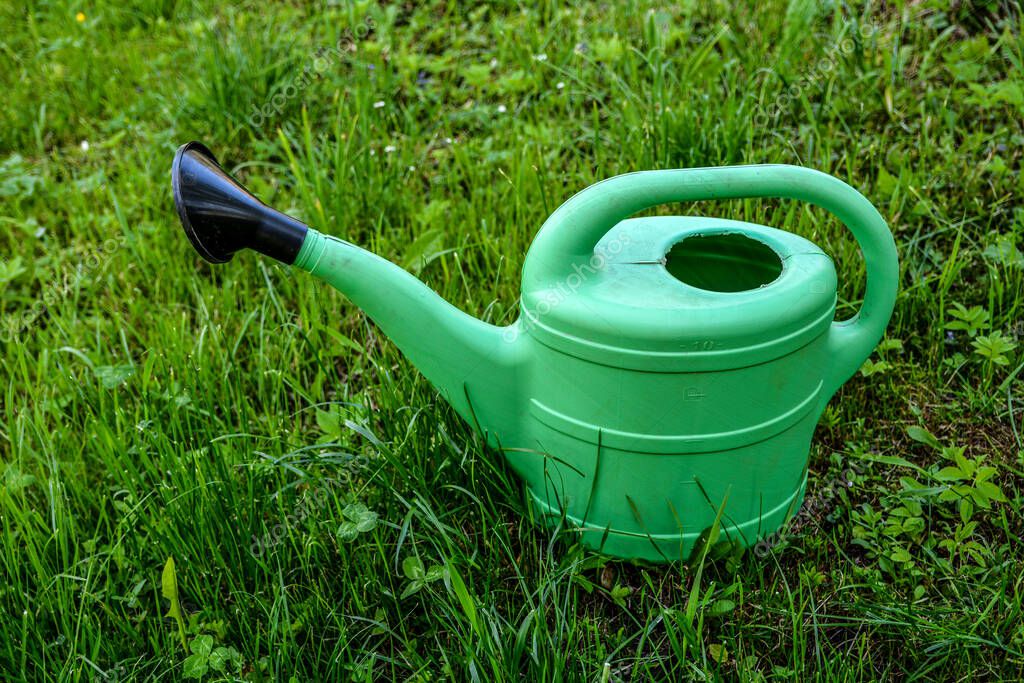 Una gran regadera de plástico verde para regar plantas de jardín se ...