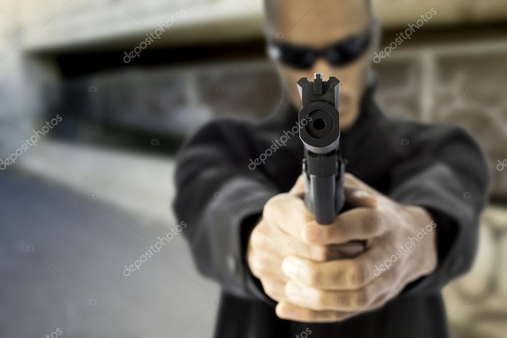 Black male pointing gun at viewer — Stock Photo © jminso #18395557