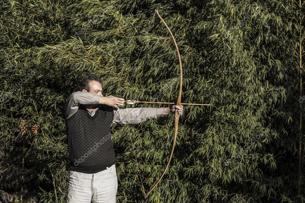 Archer with Antique Bow and Arrow Aiming — Stock Photo © BenjaminSilva ...