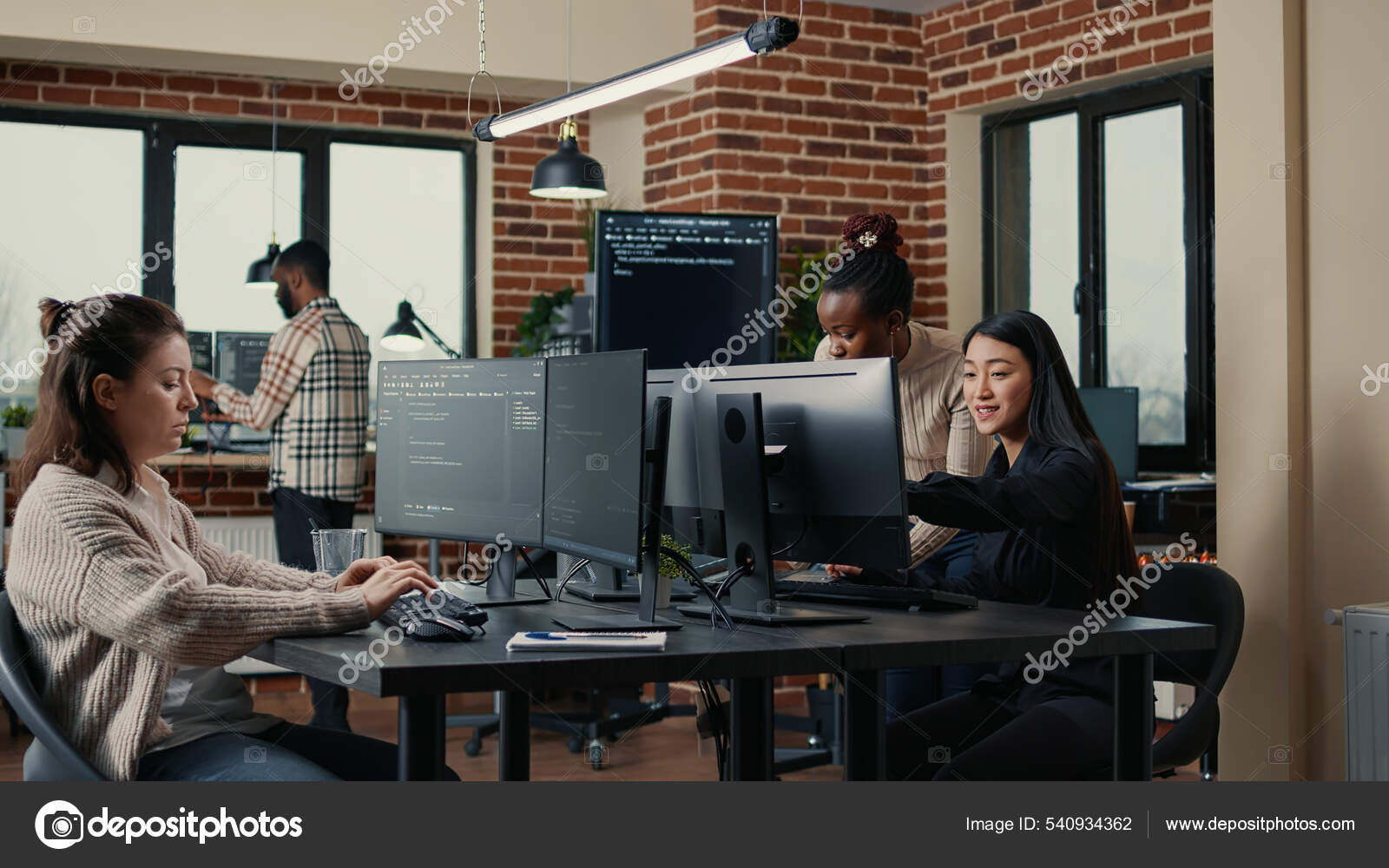 Software Engineer Typing Source Code On Computer Keyboard While Colleagues Sit Down At Desk