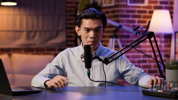 Lifestyle influencer recording chat on podcast episode at audio station ...