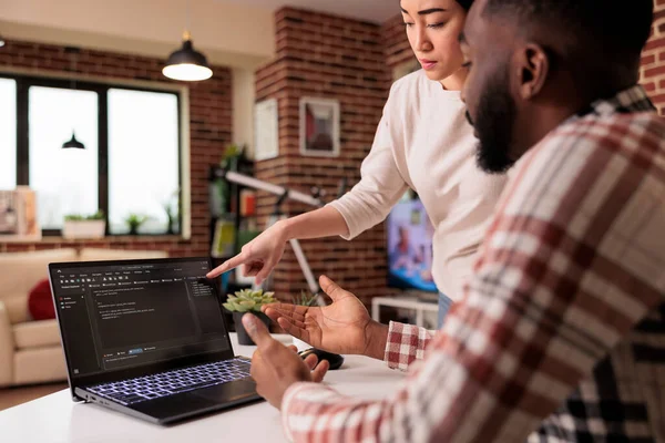 Programmers couple coding security firewall on laptop, using html and temrinal window to develop ...