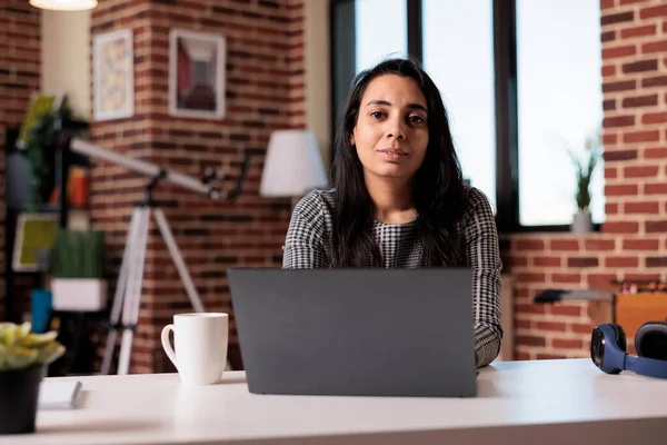 Portrait of indian woman working remotely from home on laptop at desk ...