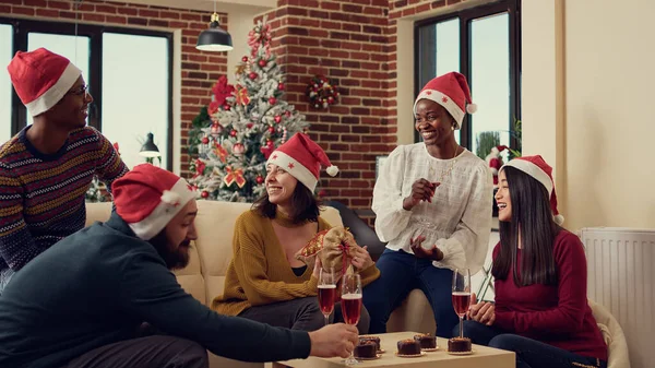 Multiethnic group of people giving gifts with ribbon as holiday ...