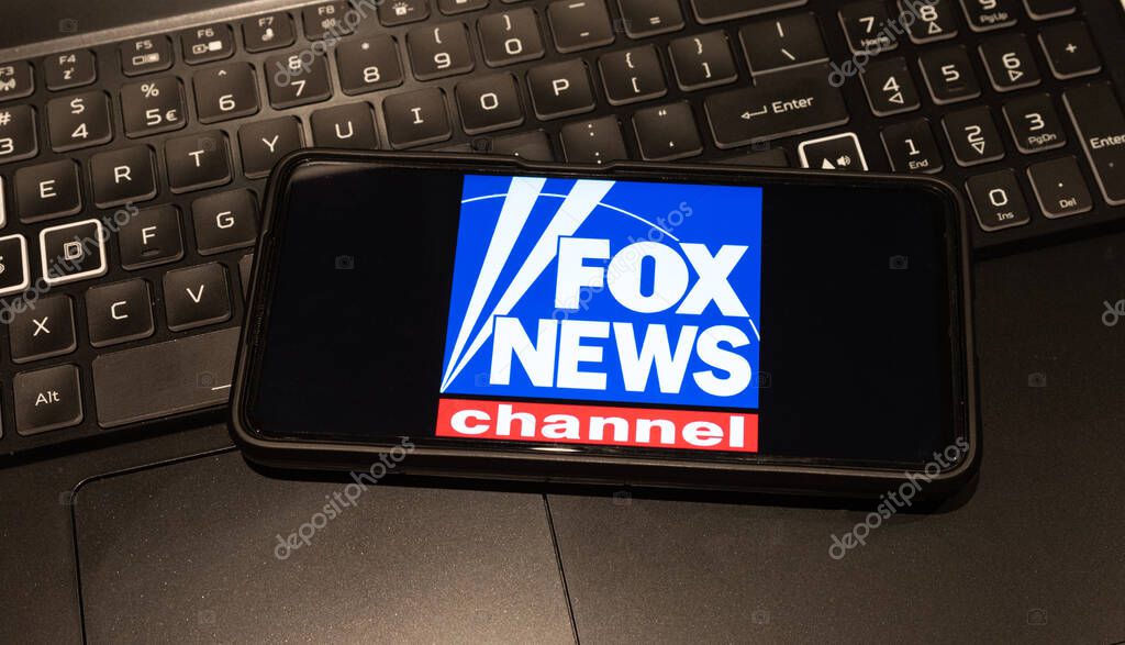 fox news channel logo on mobile phone , background is a keyboard ...