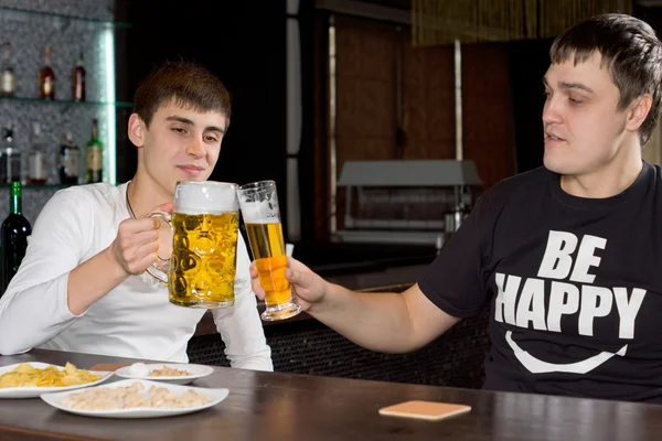 Two men friends drinking beer in a pub - Stock Image - Everypixel