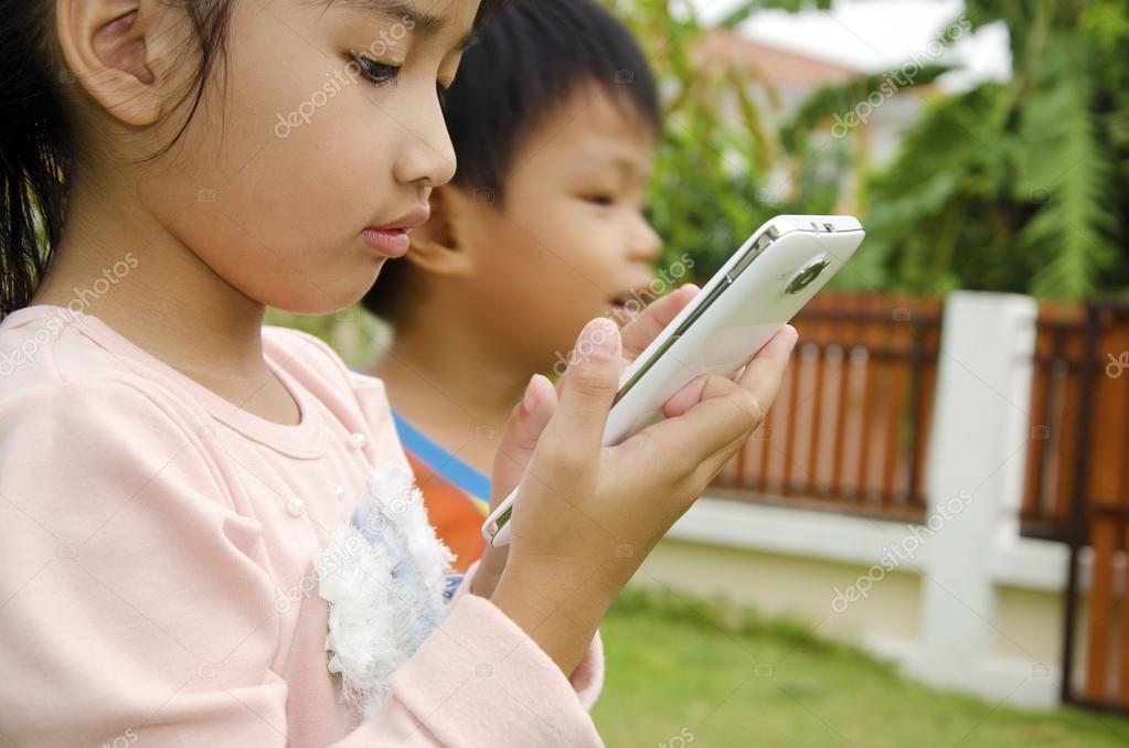 Kids playing phone — Stock Photo © intararit #48581915