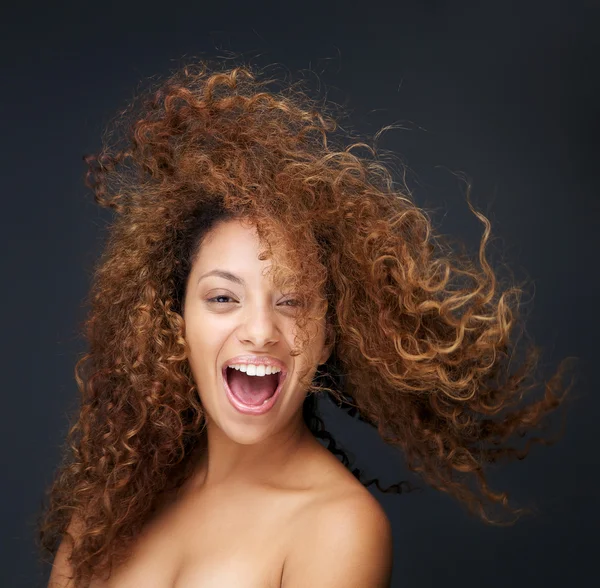 Portrait of a fun and happy young woman laughing with hair blowing ...