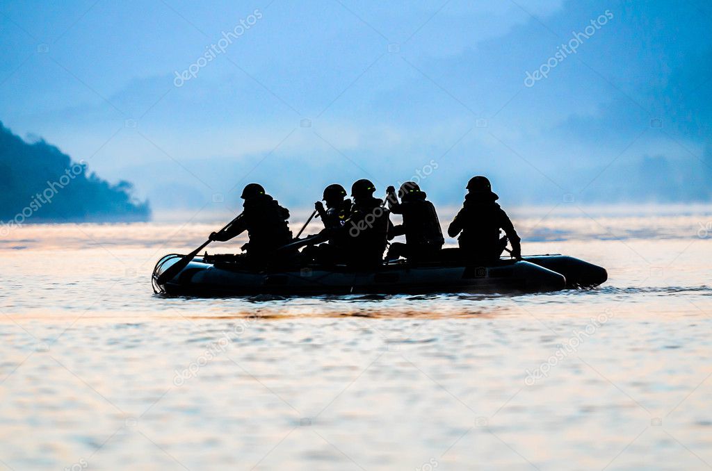 Silueta de soldados remando bote de goma en el lago 2024