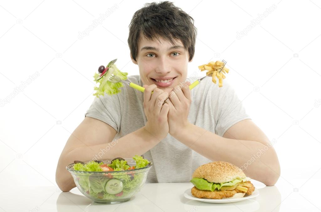 Man holding two forks, one with healthy organic salad and one with ...