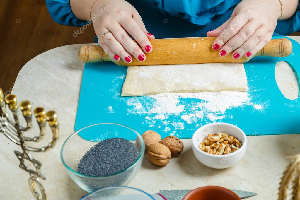 Las manos de las mujeres extienden la masa. Galletas Gomentash con ...
