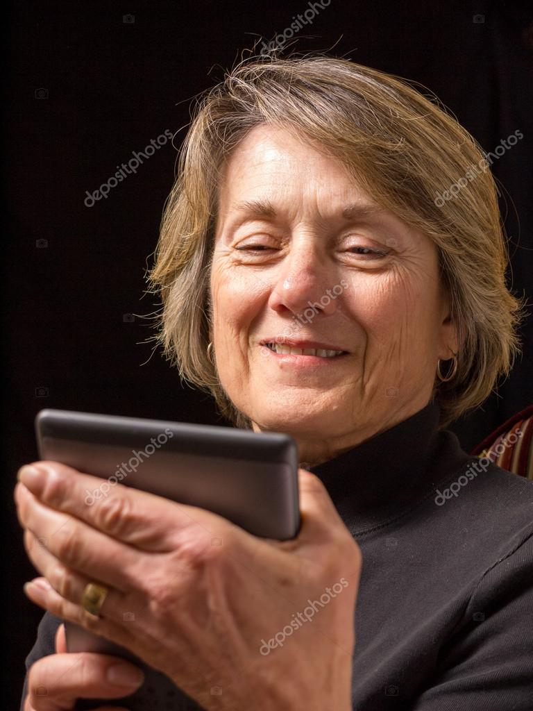 Happy older woman using new technology Stock Photo by ©dogfordstudios ...
