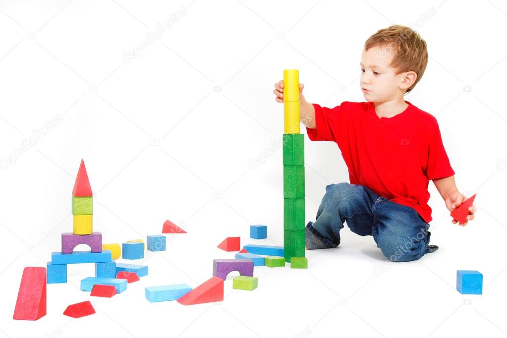 Niño jugando con bloques de construcción sobre blanco: fotografía de ...