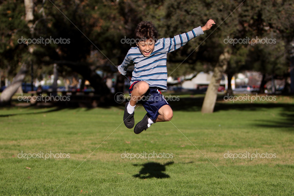 niño saltando en el parque — Fotos de Stock © dmediapro #18095077