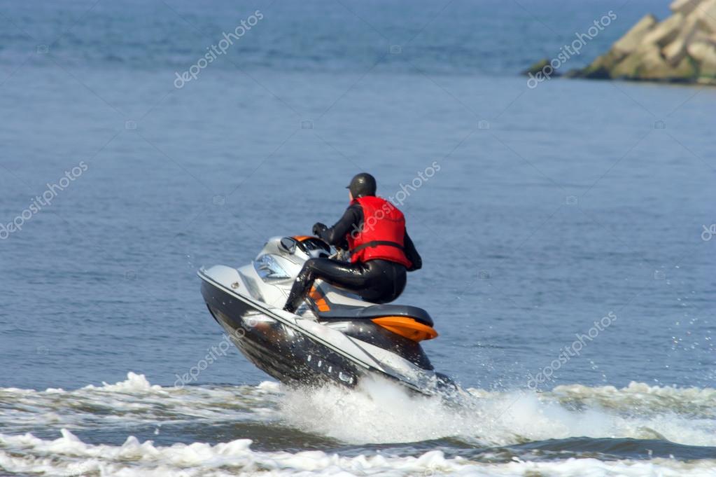 Jet ski en acción con spray de agua sobre el mar azul 2024