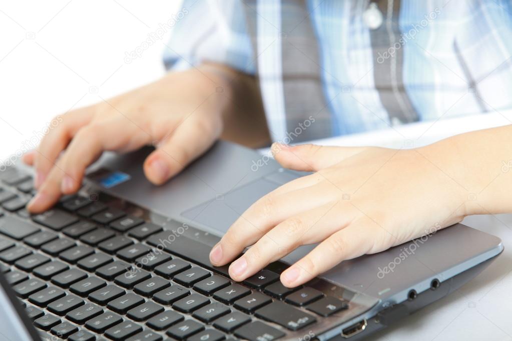 Boy's hand typing on laptop keyboard Stock Photo by ©Voyagerix 31907643