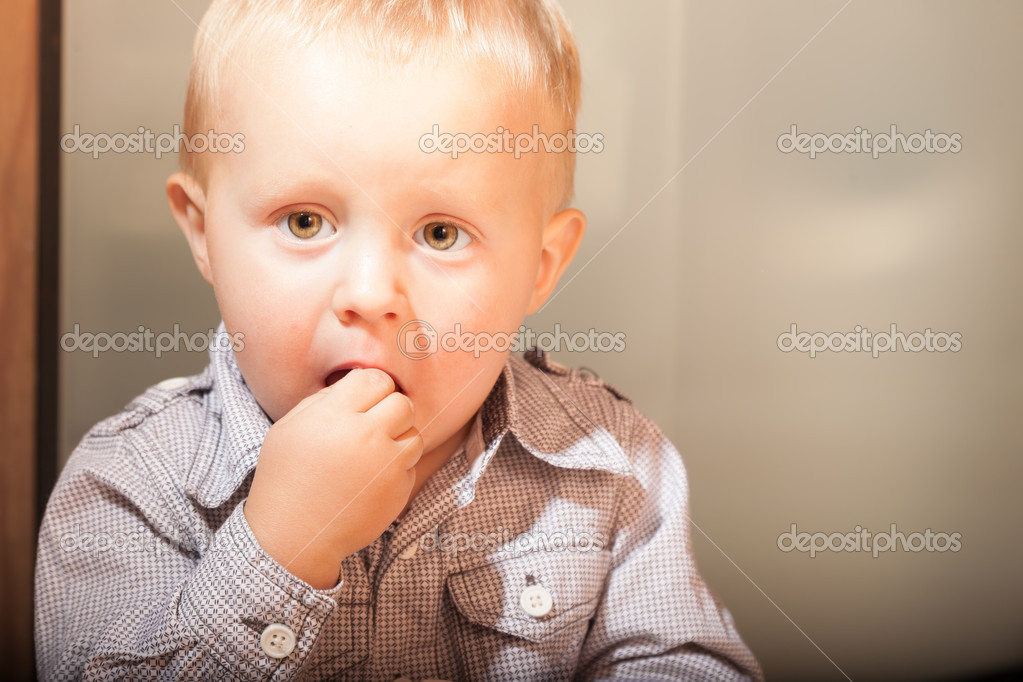 Little child eating something at home Stock Photo by ©Voyagerix 48822131