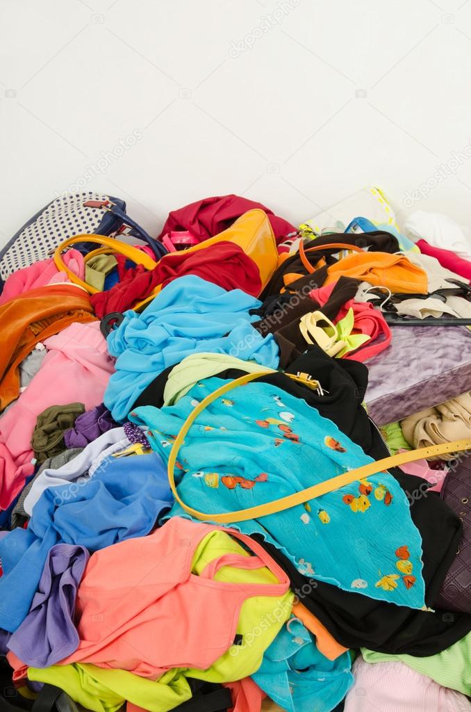 Close up on a big pile of clothes and accessories thrown on the ground ...