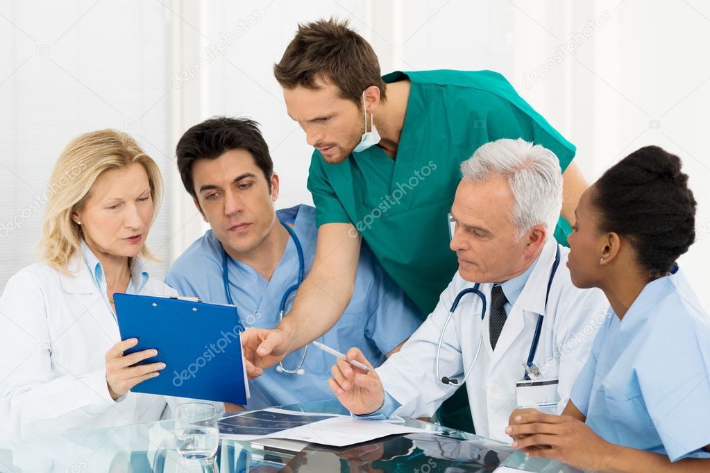 Team Of Doctors Examining Reports — Stock Photo © ridofranz #24462011 Team Of Doctors Examining Reports — Stock Photo © ridofranz #24462011
