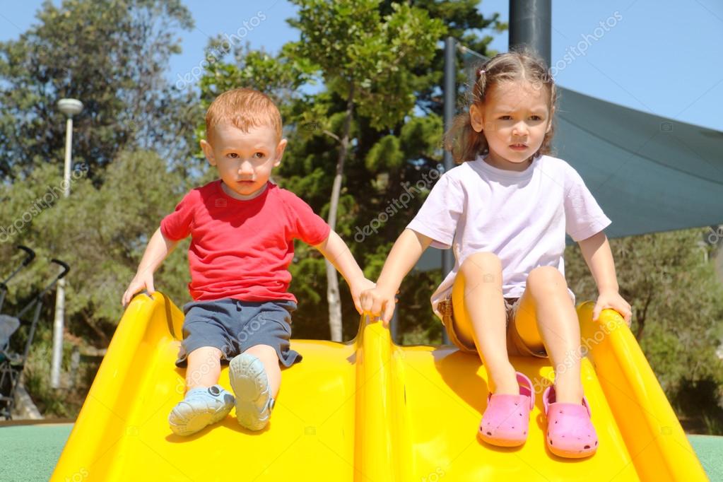 Two children playing on kids slide — Stock Photo © sdenness #12742416