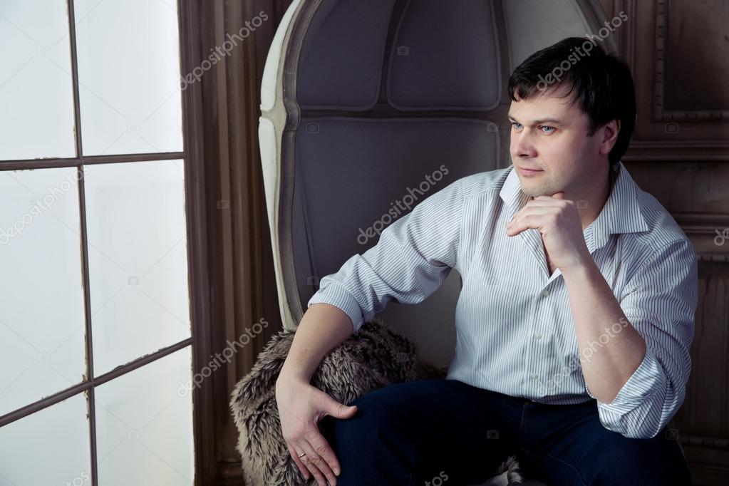Fotos de Hombre guapo sentado en una silla vieja - Imagen de ...