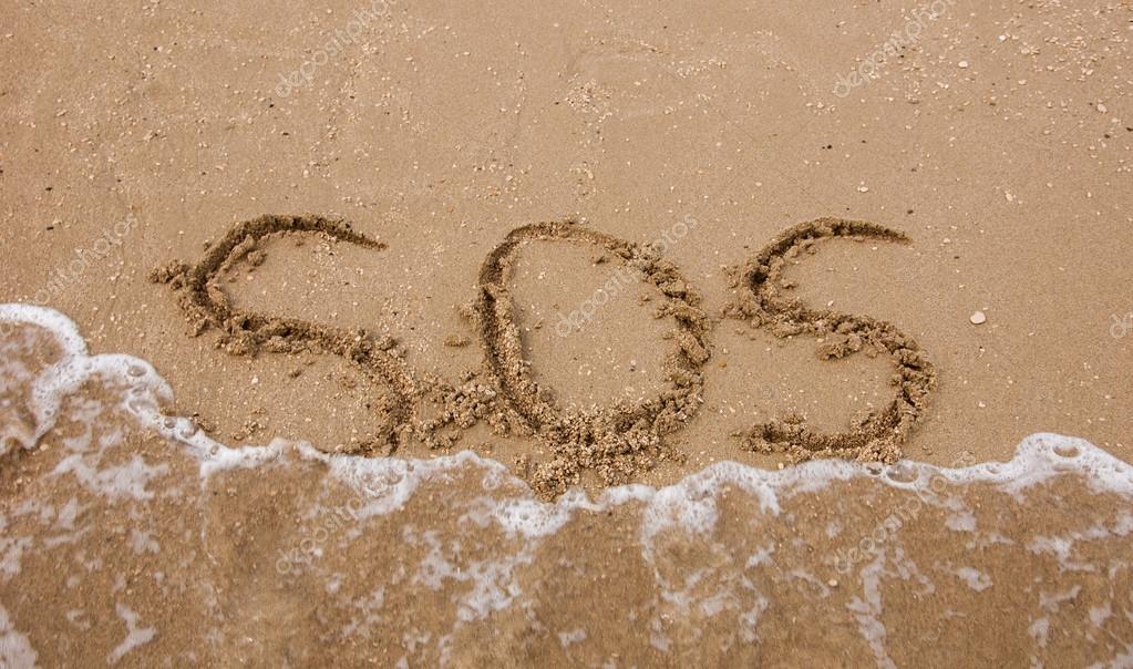 SOS inscription on beach sand washed by sea wave — Stock Photo ...