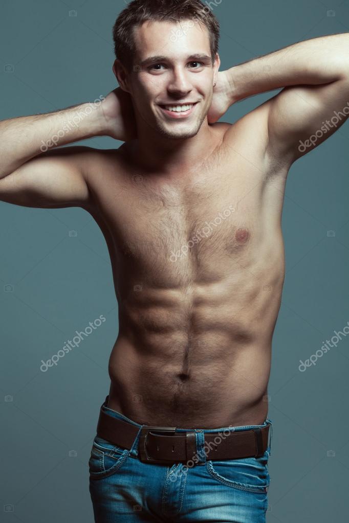 Emotive portrait of handsome boy with perfect body in blue jeans Stock ...