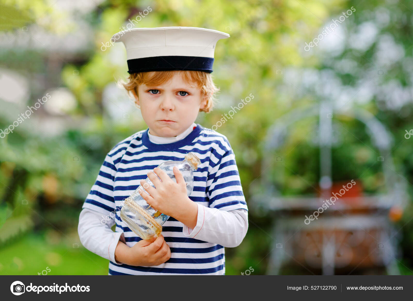 Sad crying little kid boy in sailor capitain hat and uniform playing ...