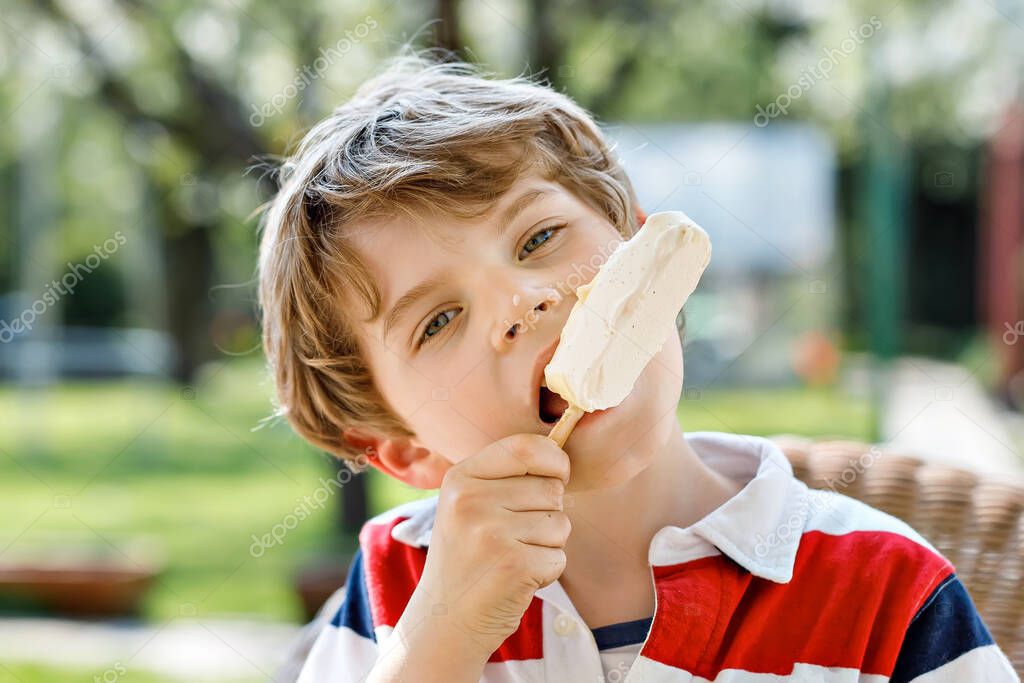 Un niño de preescolar comiendo helado en verano. Niño feliz con postre ...