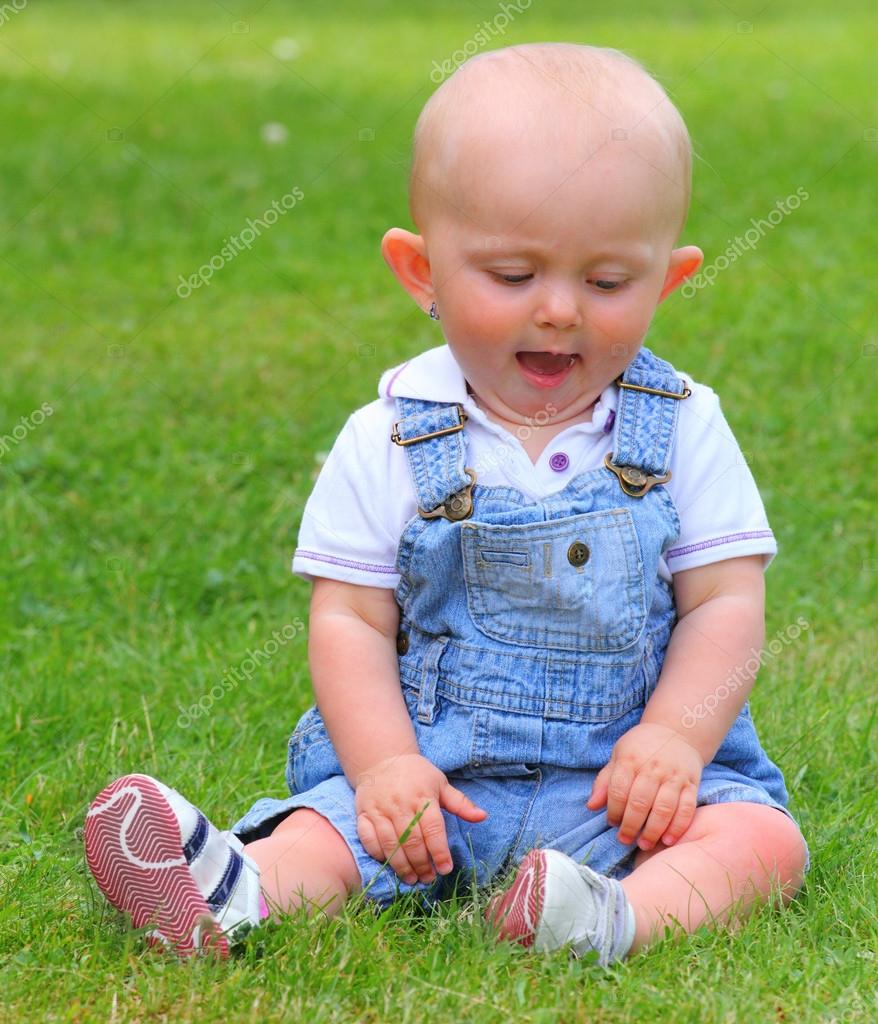 Little child sitting on a grass. Stock Photo by ©vladvitek 32826401