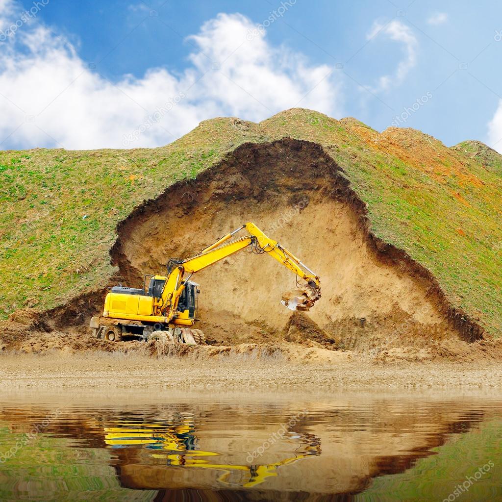 An excavator in old mine. Damaged landscape before recultivation. Stock ...
