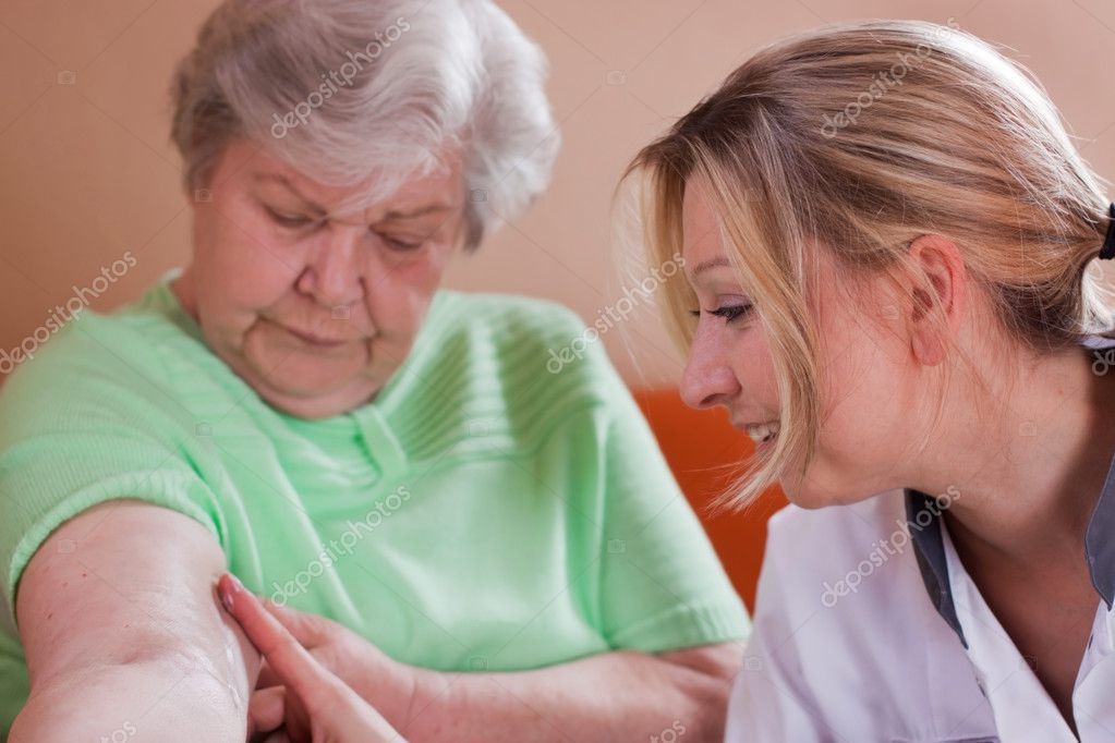 Geriatric nurse cares for elderly woman's arm Stock Photo by ©pasiphae ...