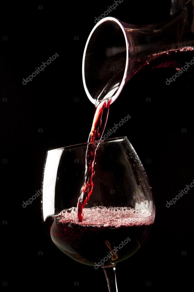 Red wine splash on a glass on black background. Stock Photo by ...