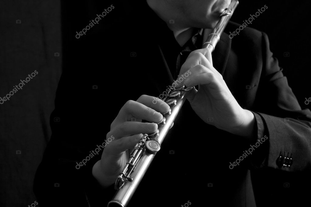 Professional flutist musician playing flute on black background Stock ...
