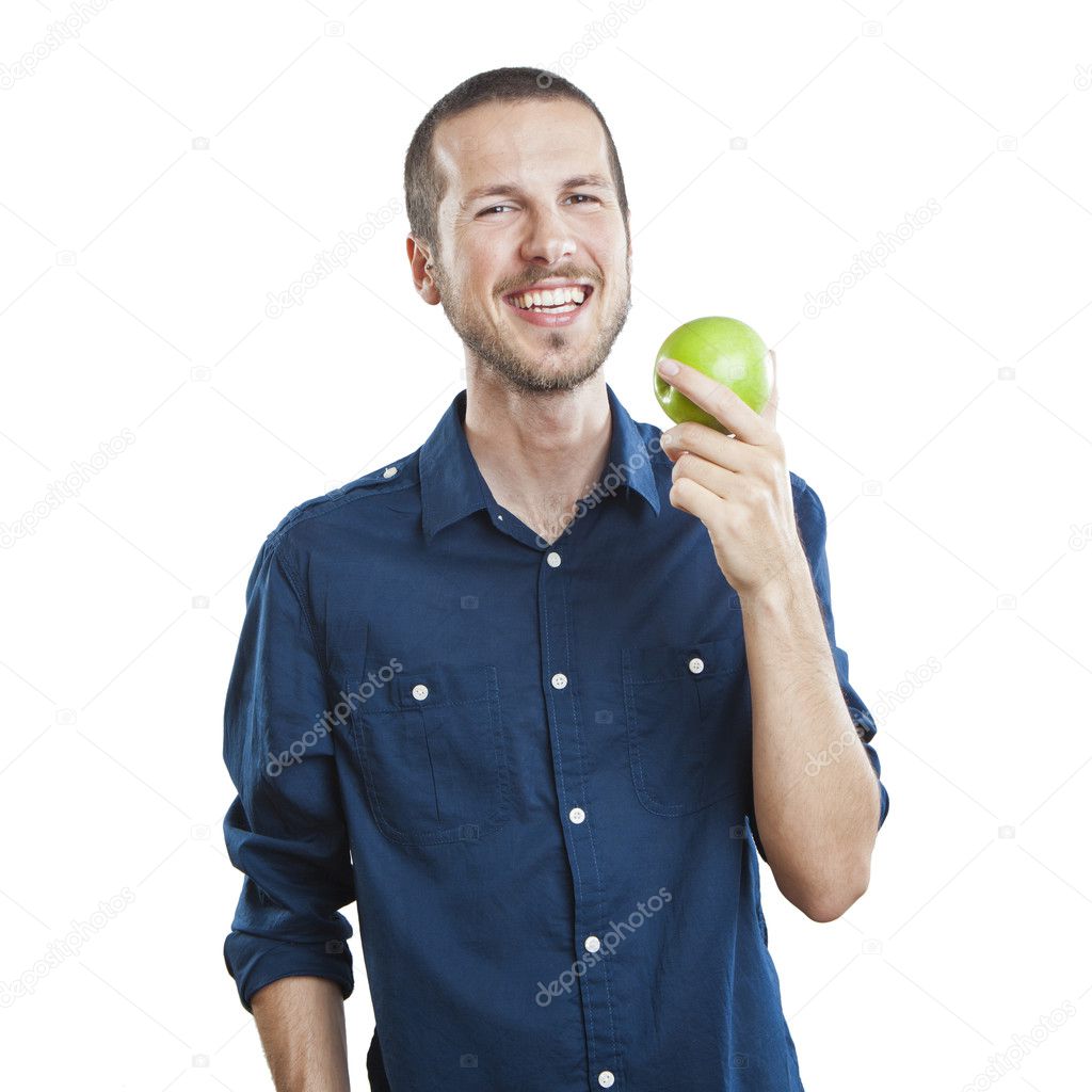 Cheerful beautiful man eating apple, isolated over white background ...
