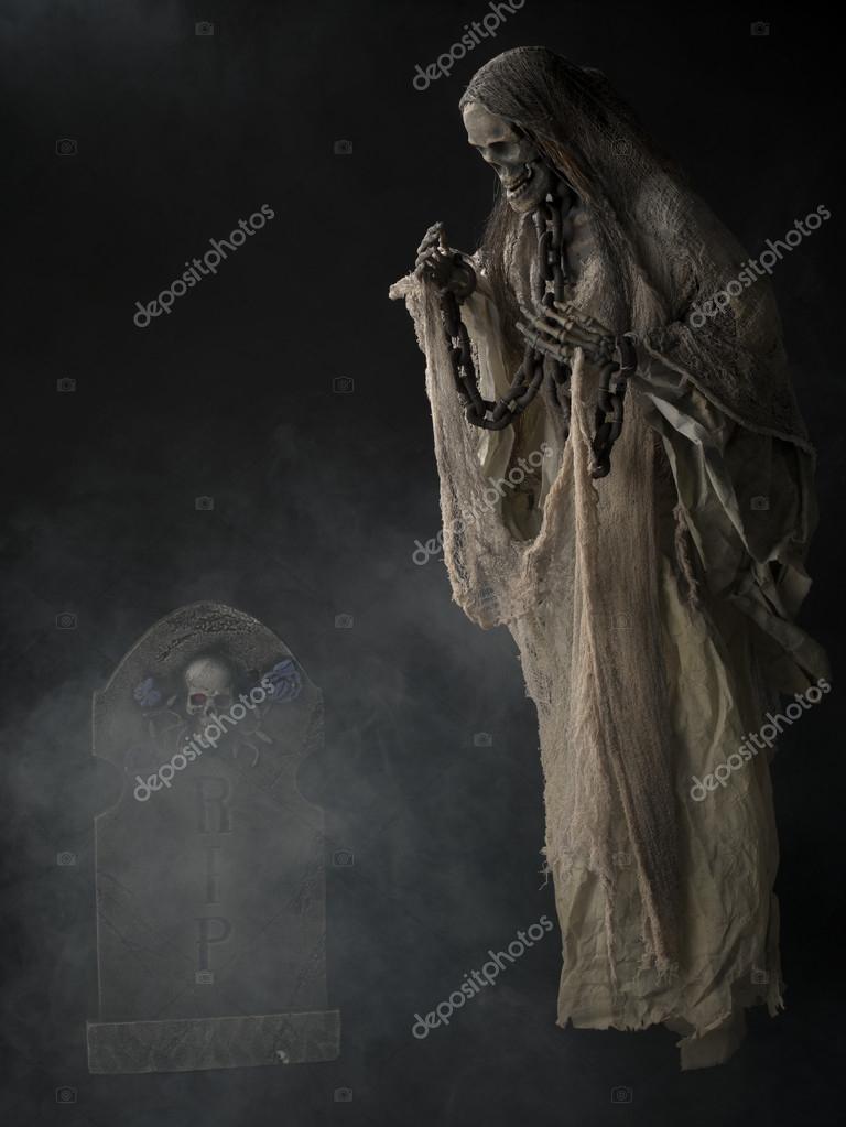 View of a human skeleton covered with chain by tombstone — Stock Photo ...