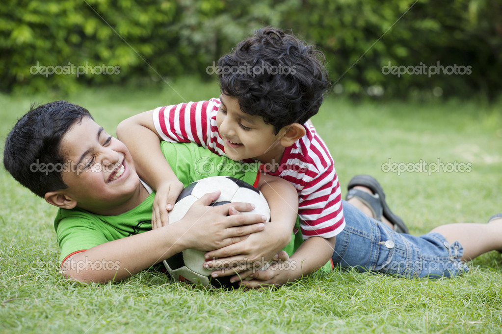 hermanos alegres jugando con un balón de fútbol — Foto de stock ...