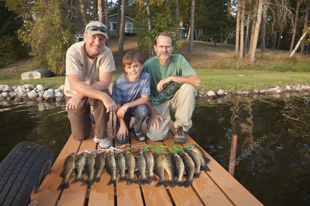 Two men and a boy posing with catch of fish — Stock Photo © Willard ...