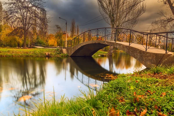 Autumn - Old bridge in autumn misty park — Stock Photo © Gorilla #67423715