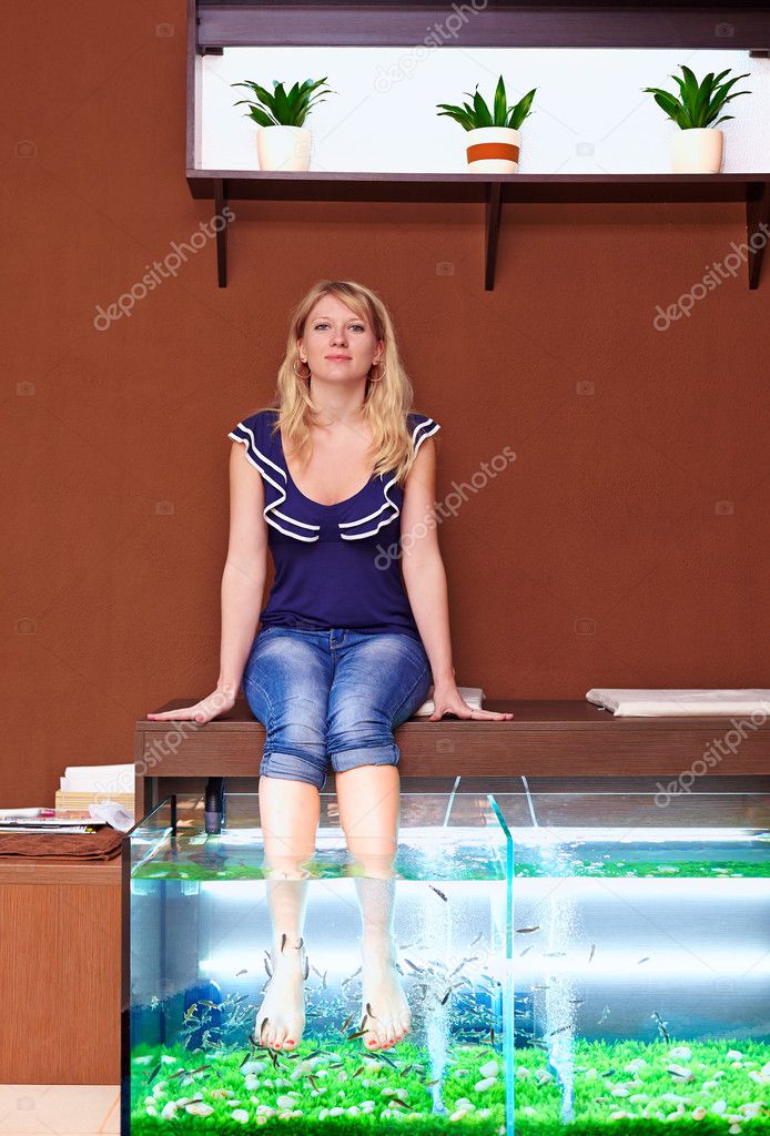 Young girl taking fish pedicure treatment, rufa garra spa procedure ...