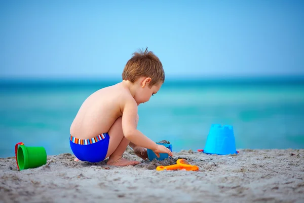 Cute kid sunbathing on colorful beach Stock Photo by ©olesiabilkei 31601475