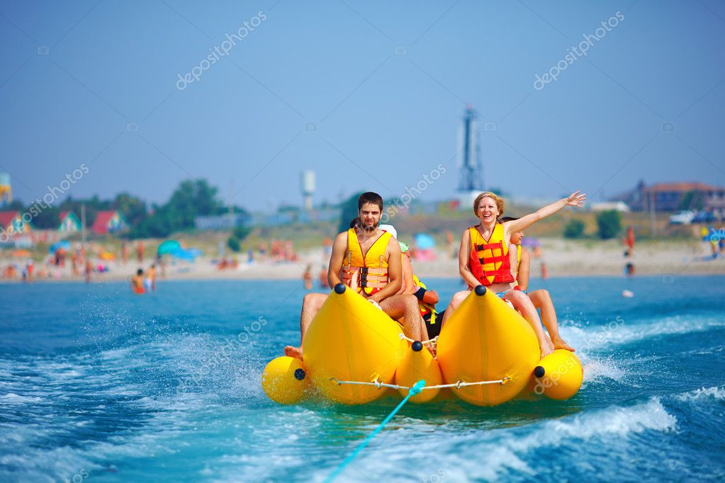 Happy people having fun on banana boat — Stock Photo © olesiabilkei ...
